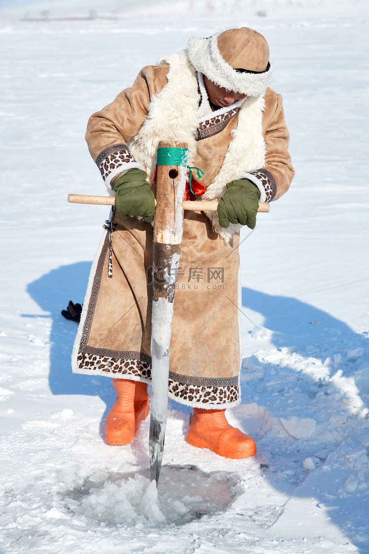寒冷的冬季在冰冻的湖面上凿冰捕鱼的人们高清摄影大图-千库网