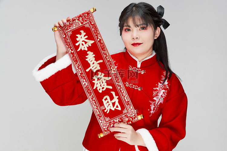 手持春联身穿喜庆汉服的可爱少女高清摄影大图-千库网
