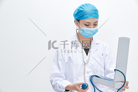 白色背景下手持血压计的门诊医生高清摄影大图-千库网