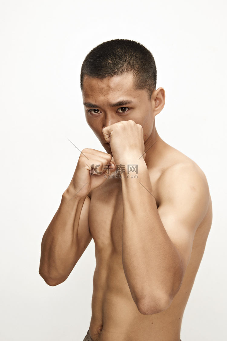 白色背景下演示自由搏击动作的亚洲功夫男性高清摄影大图-千库网