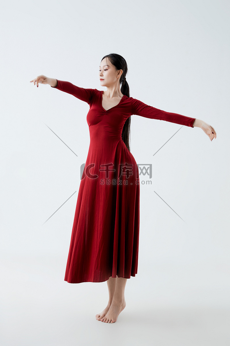 穿着红色长裙翩翩起舞的少女高清摄影大图-千库网
