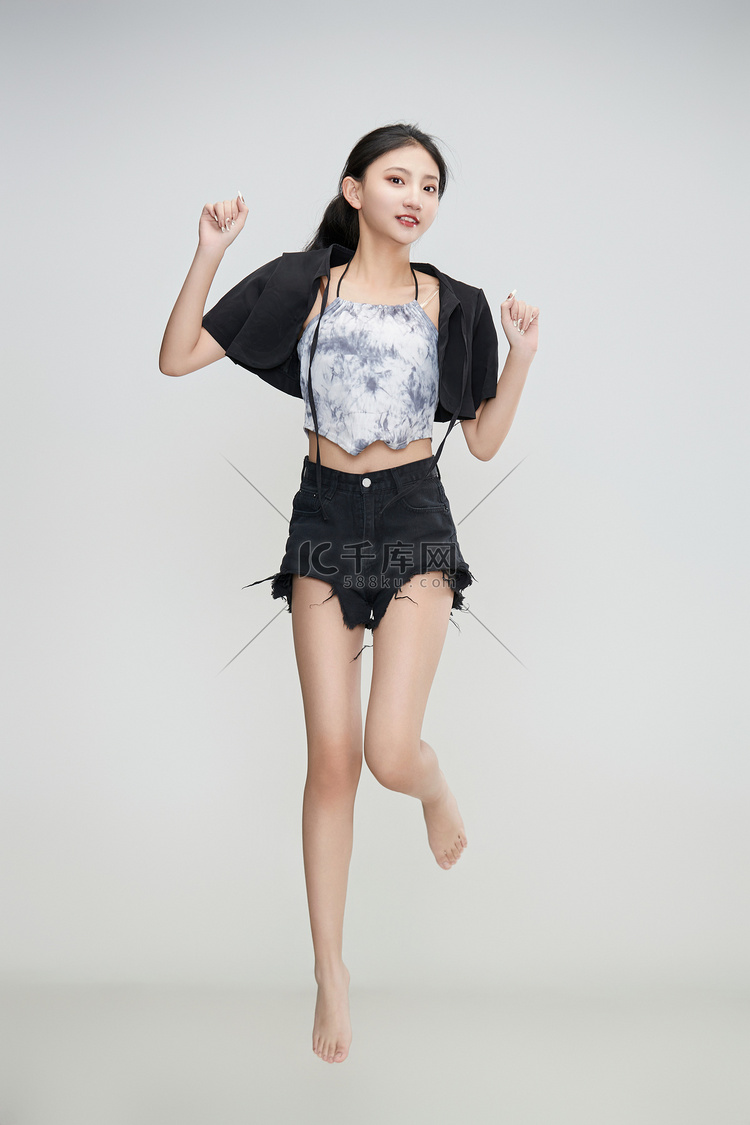 白色背景下腾空跳跃的可爱亚洲少女高清摄影大图-千库网