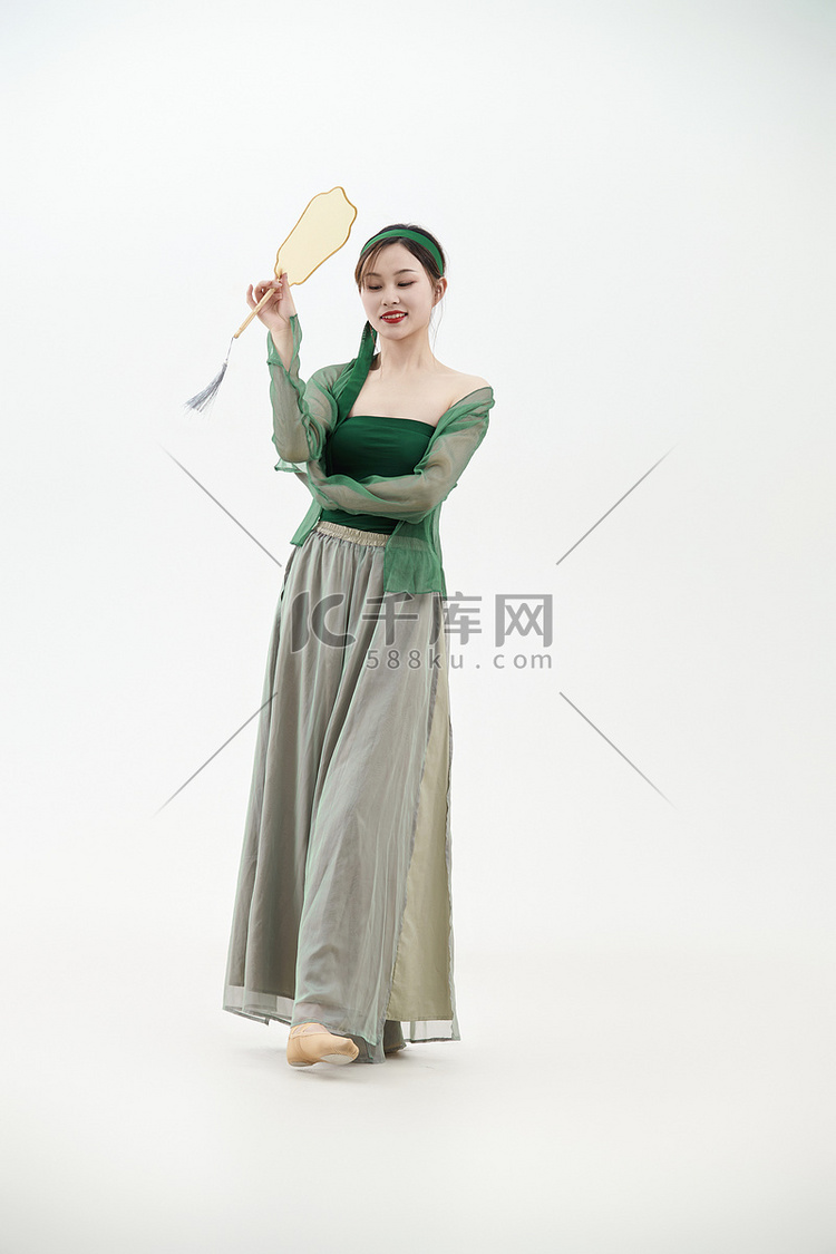 身穿青色古典舞蹈服装手拿蒲扇跳舞的少女高清摄影大图-千库网