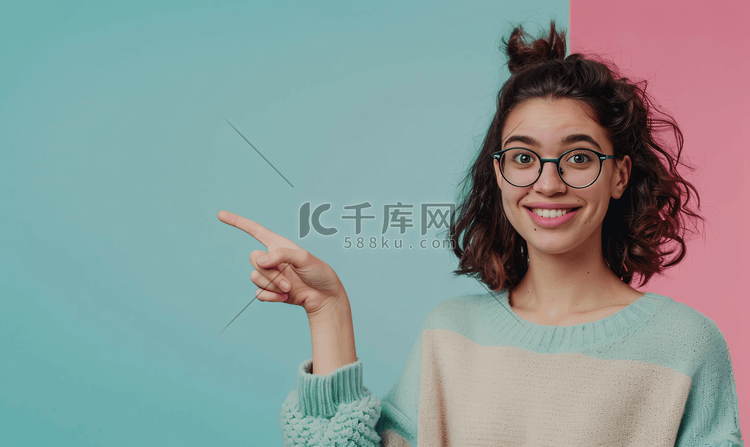 戴眼镜的年轻黑发学生指着一边微笑高清摄影大图-千库网