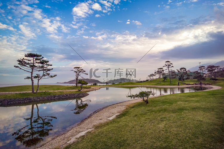 秋日的早晨海岸边蓝天白云树木倒影在水面上高清摄影大图-千库网