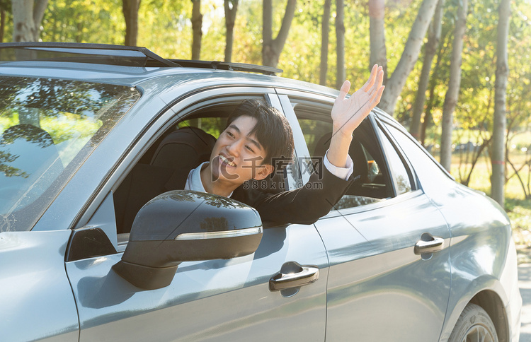 头探出车窗的专业男司机，伸手打招呼高清摄影大图-千库网