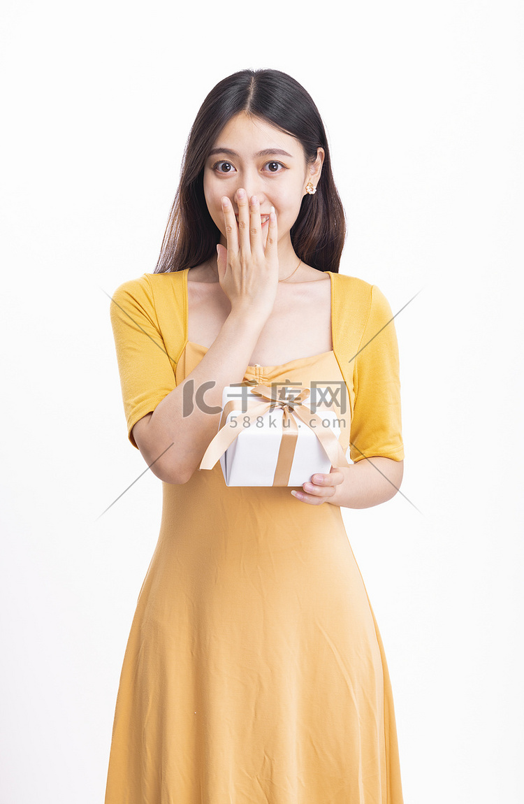 穿着黄色连衣裙拿着礼物盒子的女人高清摄影大图-千库网