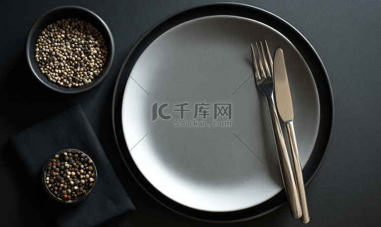 黑桌上的碗记事本中的圆盘餐刀叉黑胡椒的顶视图高清摄影大图-千库网
