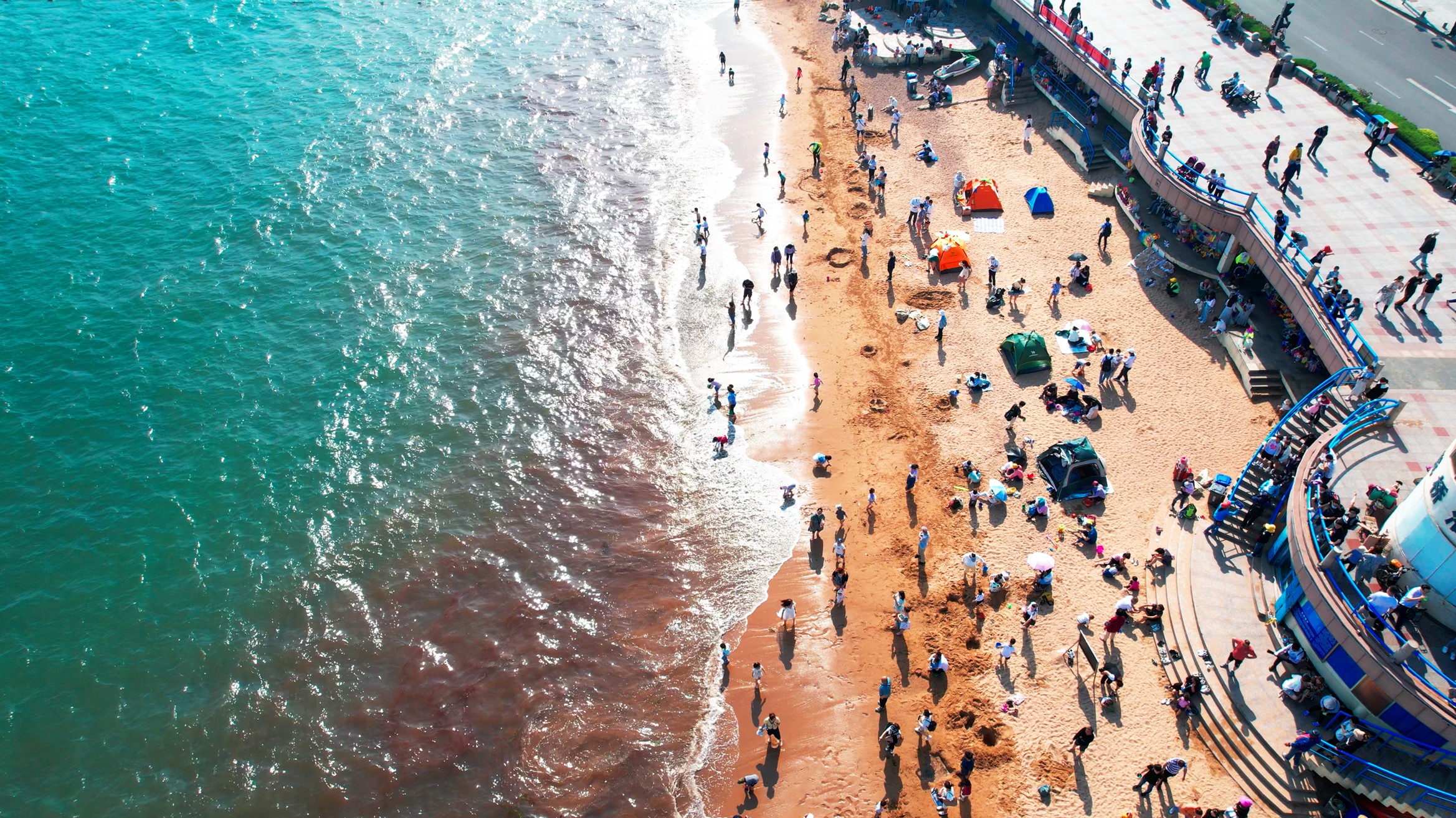 4k航拍夏天青岛栈桥浴场游客海边游玩视频特效素材-千库网